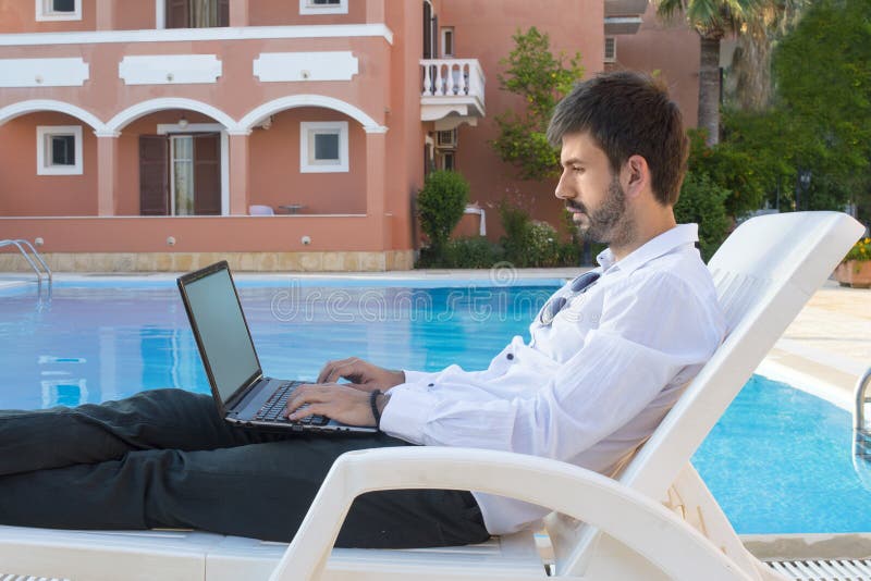 Young Businessman Working on His Laptop by the Pool while on Vac Stock ...
