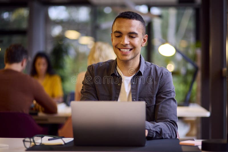 Young Businessman Working on Laptop at Desk in Office Stock Image ...