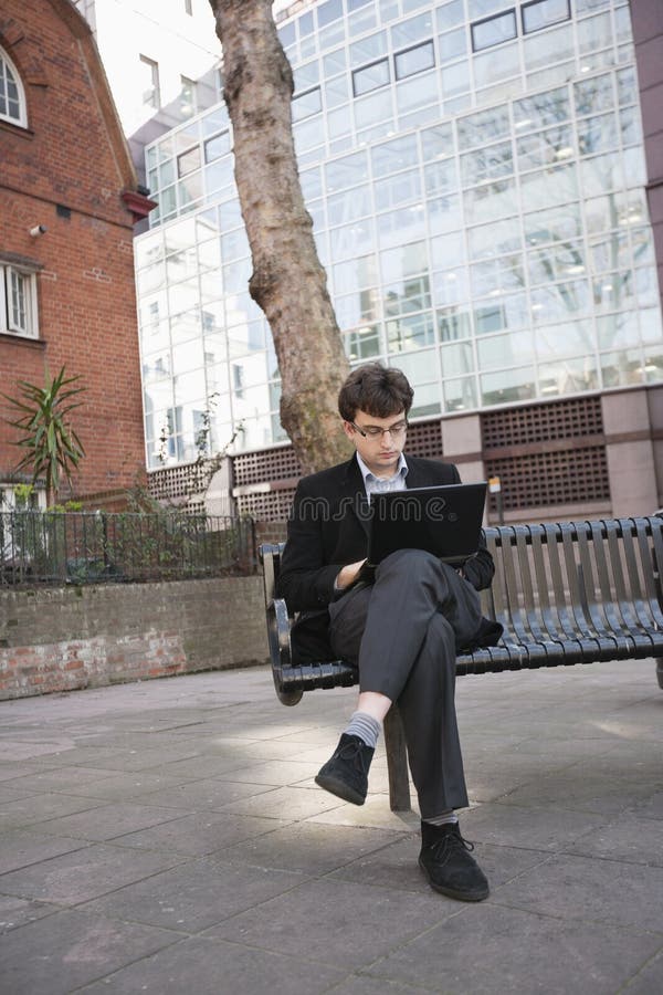 Young Businessman Working on Laptop while Sitting on Bench Stock Photo ...