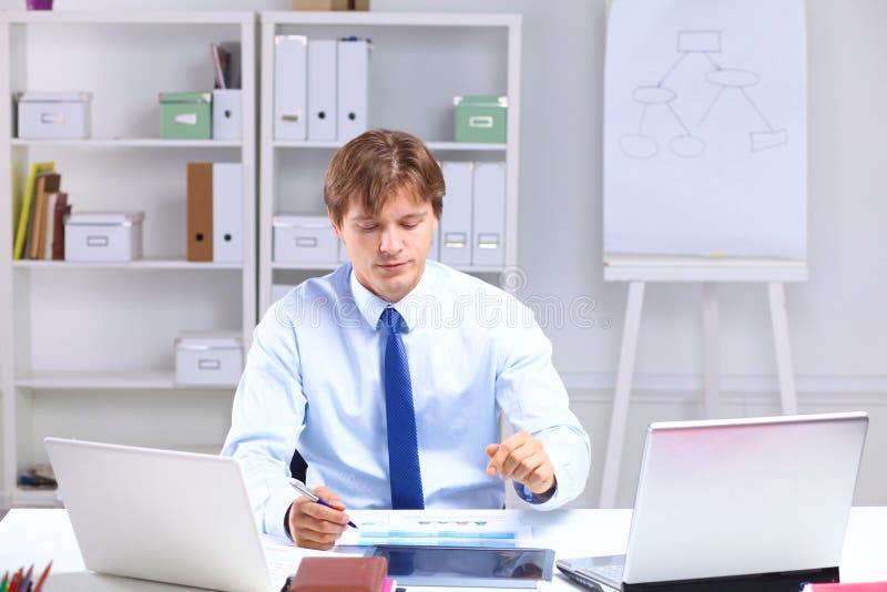 Young Businessman Working in Office, Sitting at a Table Stock Photo ...