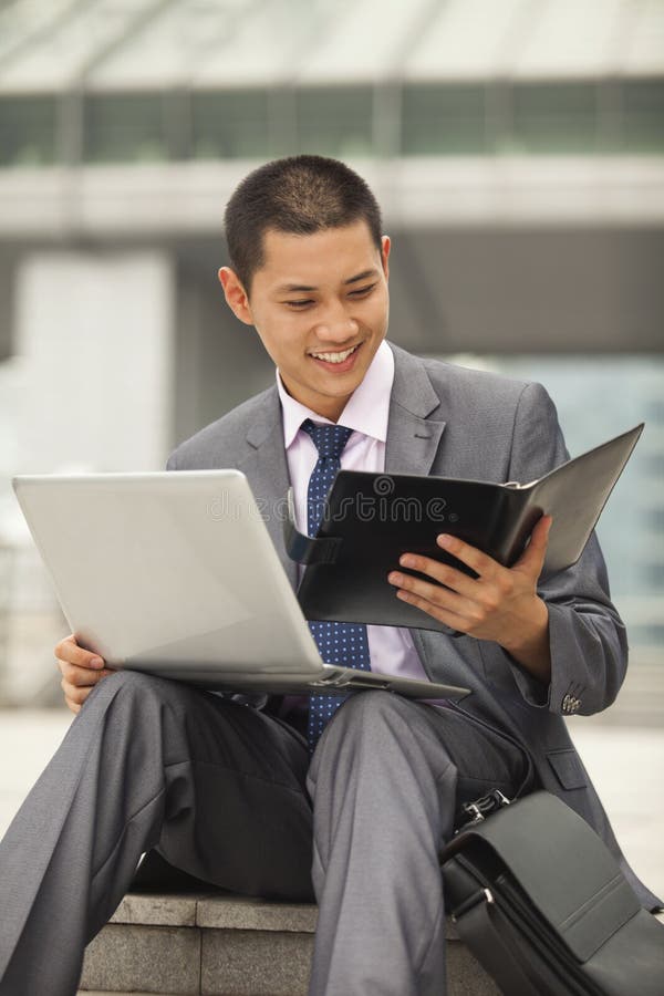 Two Young Businessmen Working Outdoor, Looking at Each Other Stock ...