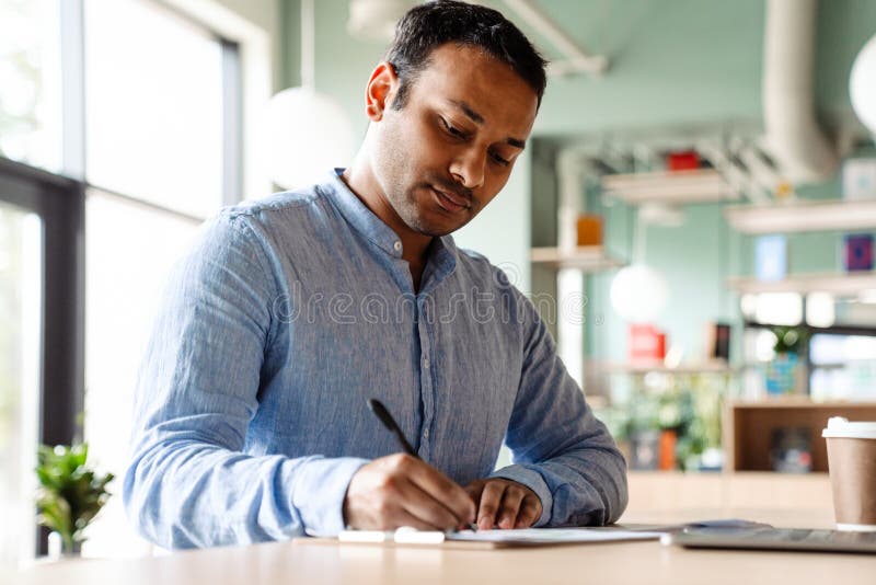 Young Businessman Writing Down Notes while Working at Office Stock ...