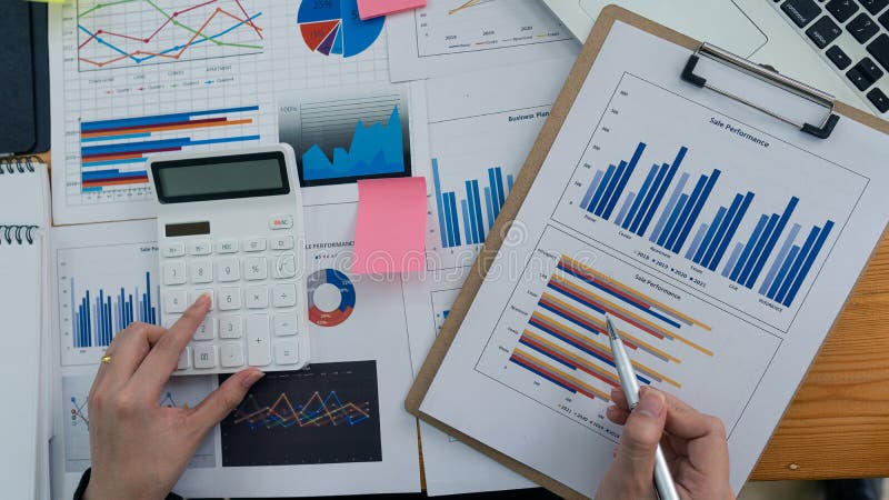 Young Businessmen Analyze Data Using Graphs and Laptop Calculators in ...