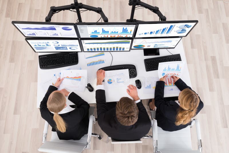 Young Businesspeople Working with Graphs on Multiple Computers Stock ...