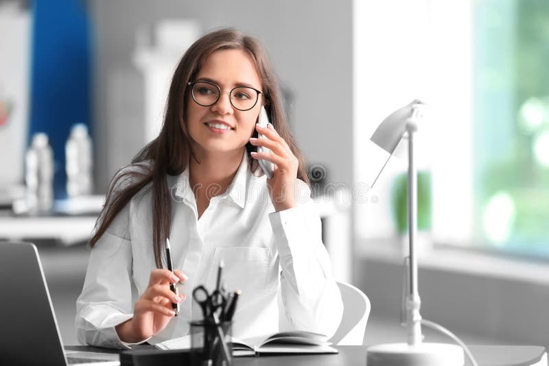 Young Businesswoman Talking by Mobile Phone in Office Stock Image ...