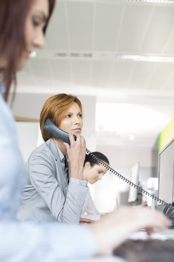 Young Businesswoman Using Landline Phone in Office Stock Image - Image ... Young Businesswoman Using Landline Phone in Office Stock Image - Image ...