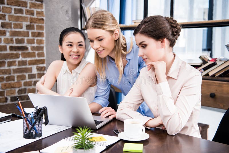 Young Businesswomen Using Laptop Together at Workplace Stock Image ...