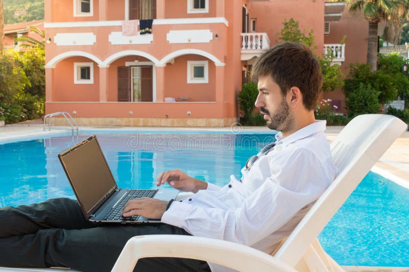 Young Bussines Man Working on His Lap Top by the Pool Stock Image ...