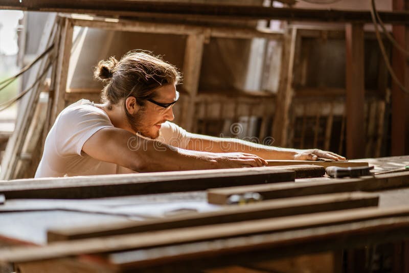 Young Carpenter Man Using Sandpaper on a Piece of Wood in Workshop ...