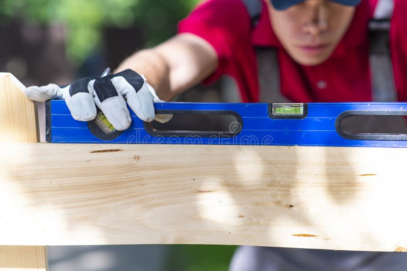 Young Carpenter Measuring Wood Using Water Spirit Level in His Work ...