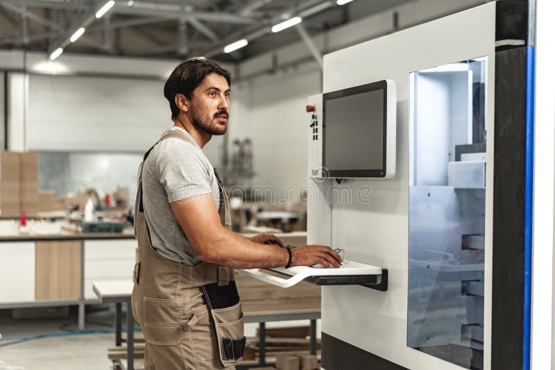 Young Carpenter Operating Machine for Wood Processing at a Furniture ...