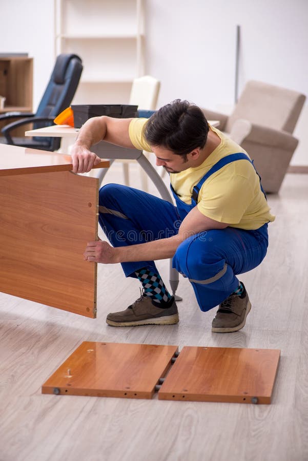 Young Male Carpenter Repairing Desk in the Office Stock Photo - Image ...