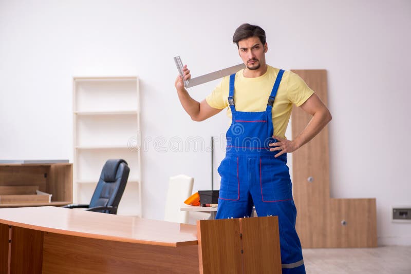 Young Male Carpenter Repairing Desk in the Office Stock Image - Image ...