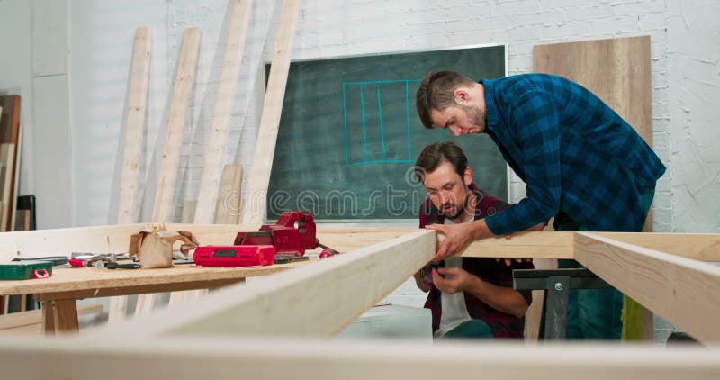 Young Carpenters Build a Solid Wood Wall in a Carpentry Workshop Stock ...