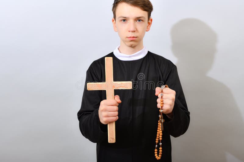 A Young Catholic Priest Holds a Cross and a Rosary in His Hand Stock ...