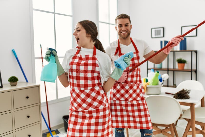 Young Caucasian Couple Cleaning Using Mop As a Guitar at Home Stock ...