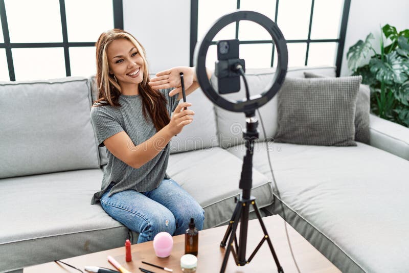 Young Caucasian Girl Making Makeup Tutorial Sitting on the Sofa at Home ...