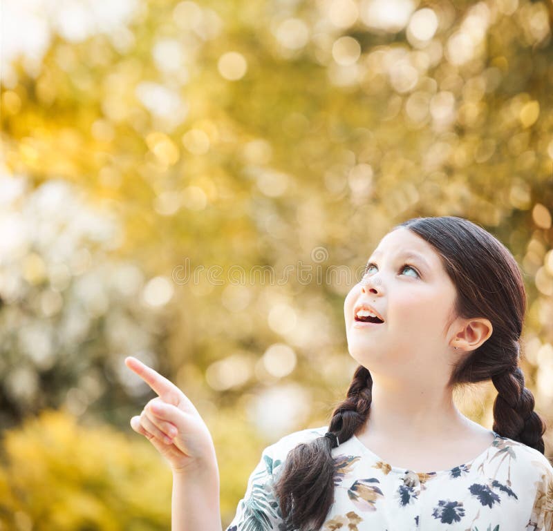 Young Caucasian Girl Pointing in a Direction in a Forest while Smiling ...