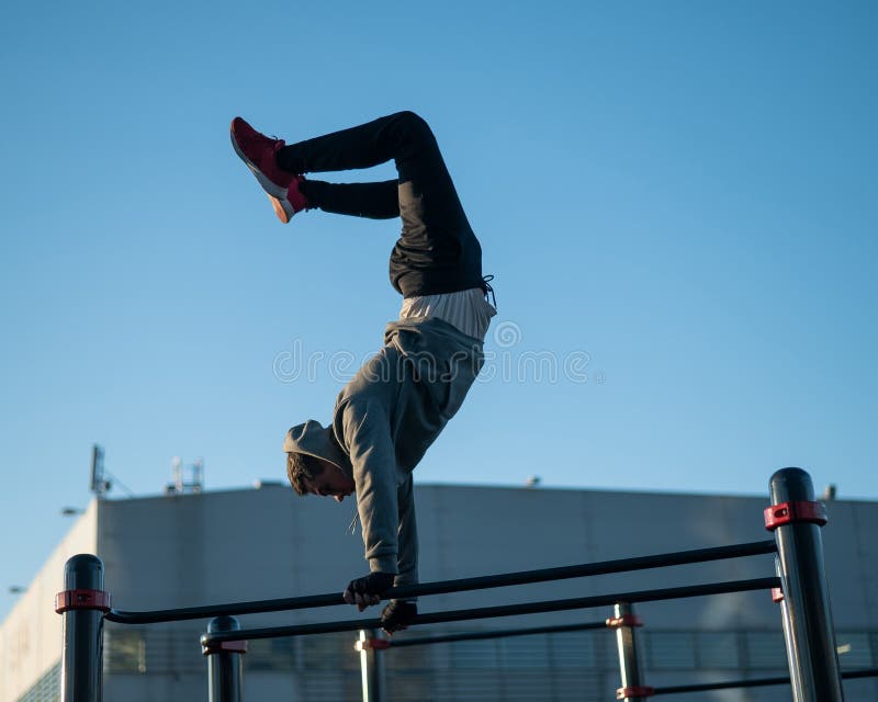 Young Caucasian Man Doing Parallel Bars Exercise Outdoors. Stock Photo ...