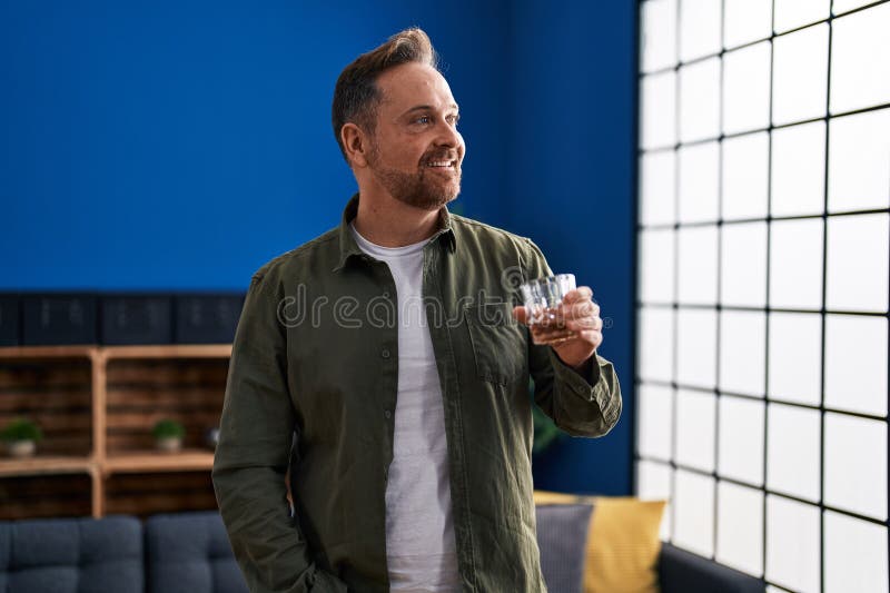 Young Caucasian Man Drinking Glass of Whisky Standing at Home Stock ...