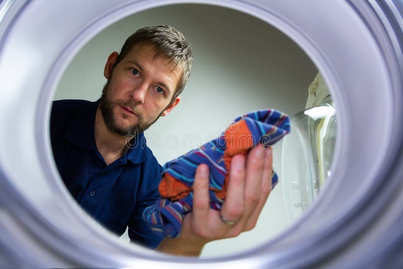 Young Caucasian Man Loading Washing Machine. Man Making Houseworks ...