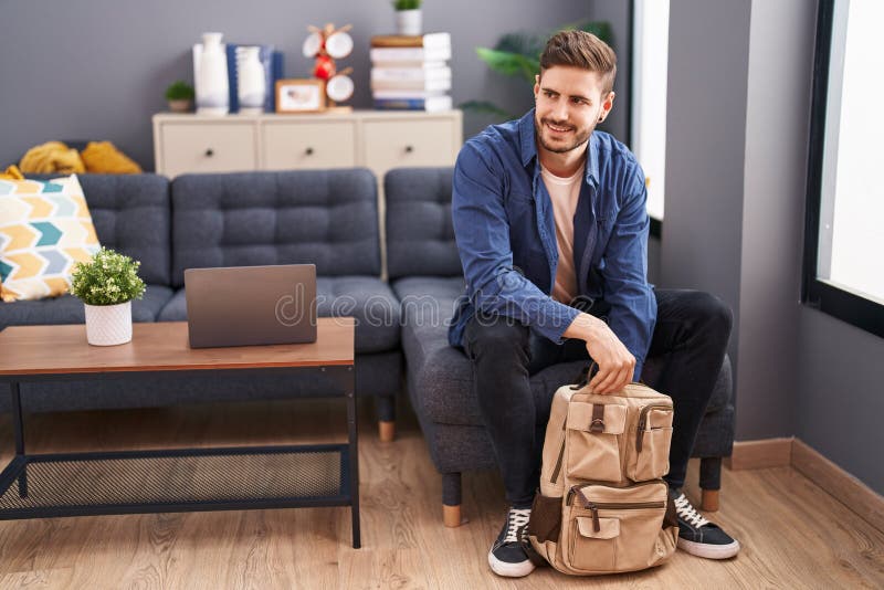 Young Caucasian Man Opening Backpack Sitting on Sofa at Home Stock ...