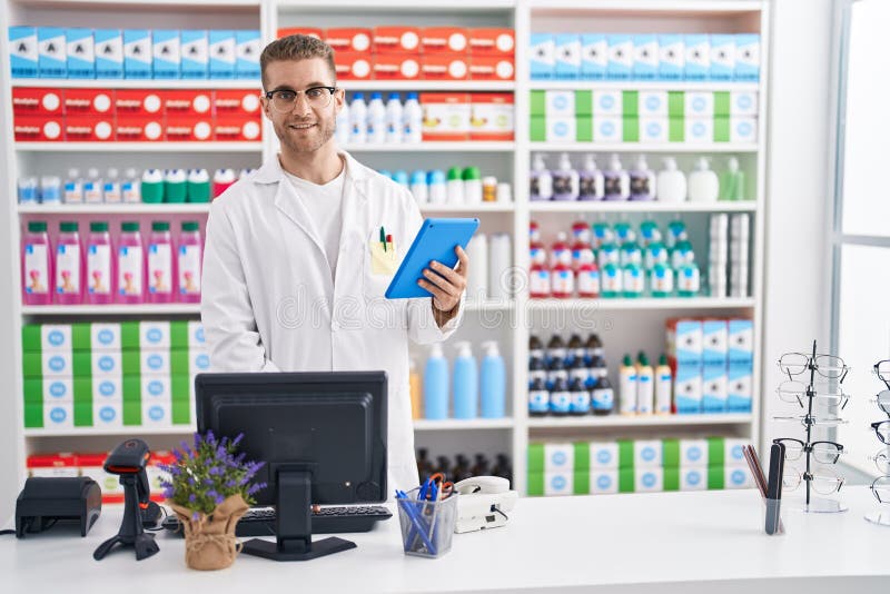 Young Caucasian Man Pharmacist Using Touchpad and Computer at Pharmacy ...