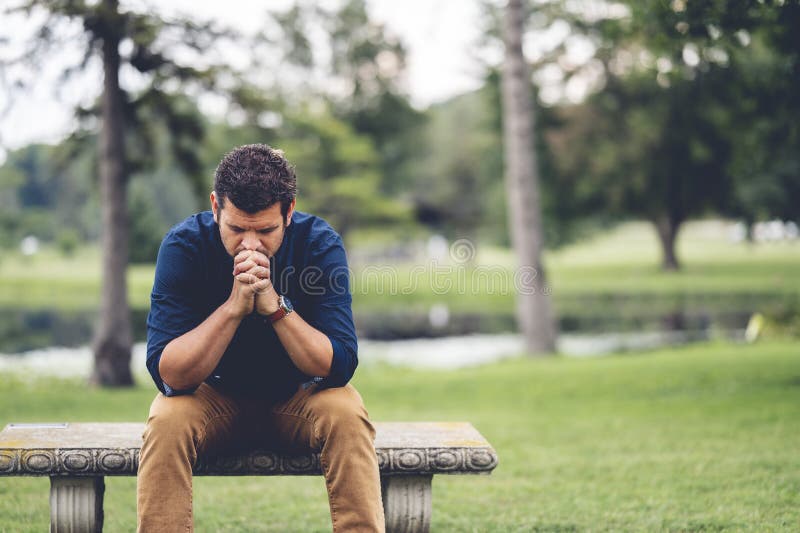 Young Caucasian Man Praying while Sitting on a Bench Stock Image ...