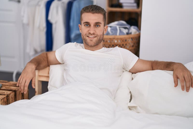 Young Caucasian Man Smiling Confident Sitting on Bed at Bedroom Stock ...