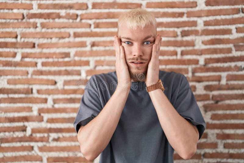 Young Caucasian Man Standing Over Bricks Wall Afraid and Shocked ...