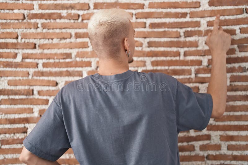 Young Caucasian Man Standing Over Bricks Wall Posing Backwards Pointing ...