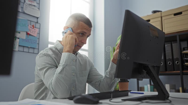 Young, Caucasian, Man Talking on the Phone while Working at a Desk in ...