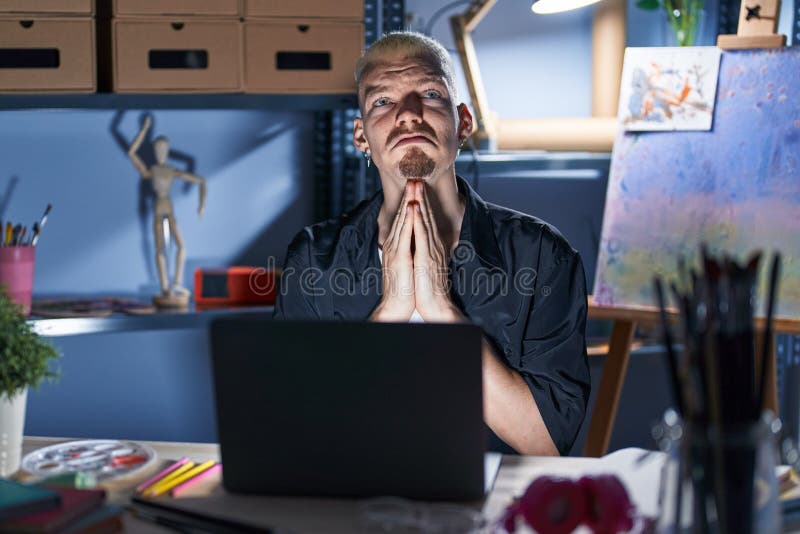Young Caucasian Man Using Laptop at Night at Art Studio Begging and ...