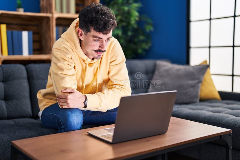 Young Caucasian Man Using Laptop Sitting on Sofa at Home Stock Photo ...