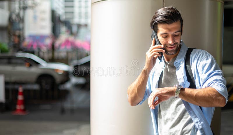 Young Caucasian Man Watching the Time and Calling on His Smartphone ...