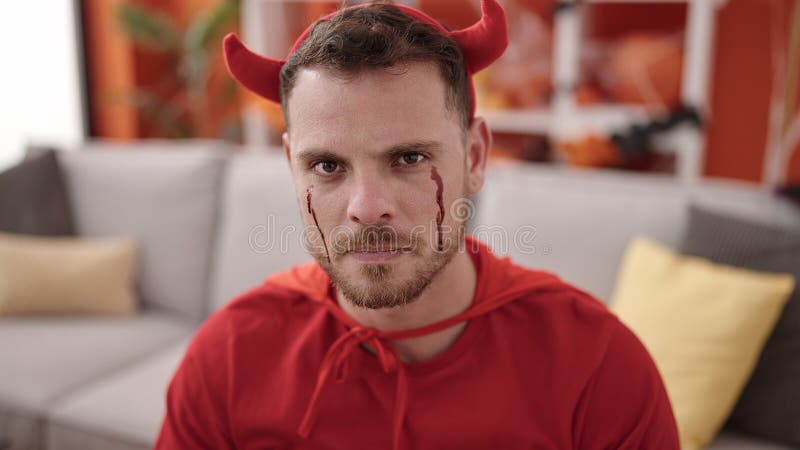 Young Caucasian Man Wearing Devil Costume Sitting on the Sofa at Home ...