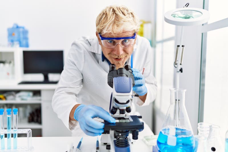Young Caucasian Man Wearing Scientist Uniform Using Microscope at ...