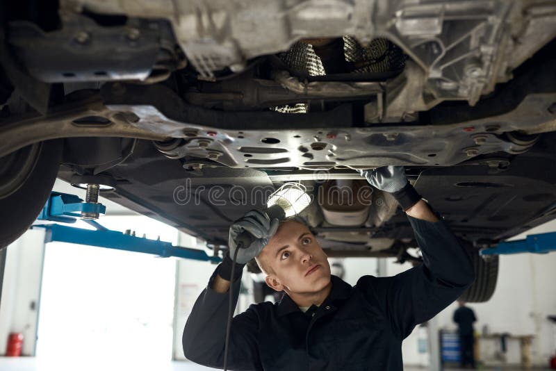 Young Caucasian Mechanic Working Under Auto Installed on Lift Stock ...