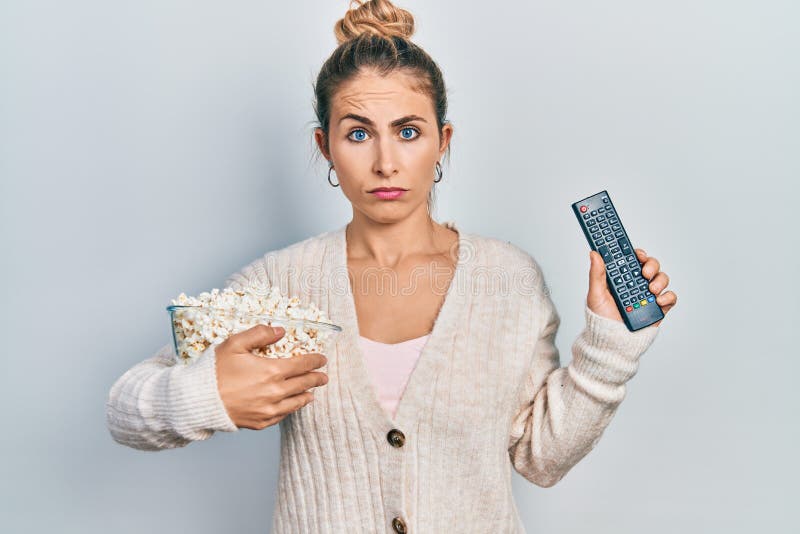 Young Caucasian Woman Eating Popcorn Using Tv Control Clueless and ...