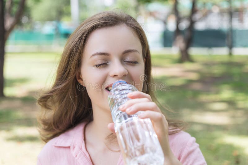 Young Caucasian Woman Girl Drinking Water from a Plastic Bottle in ... Young Caucasian Woman Girl Drinking Water from a Plastic Bottle in ...