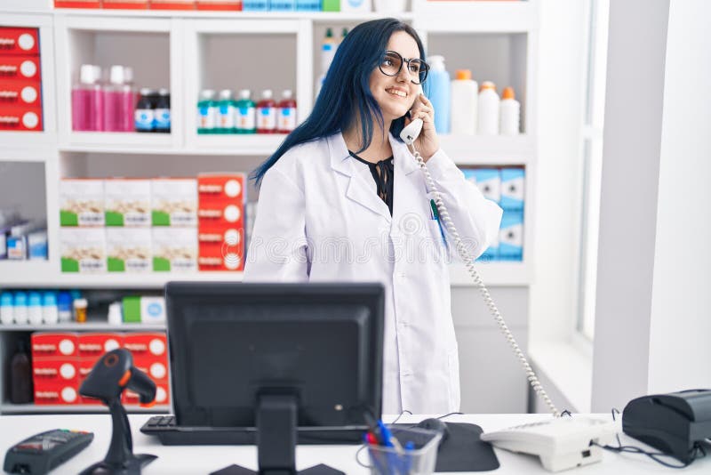 Young Caucasian Woman Pharmacist Talking on Telephone Using Computer at ...