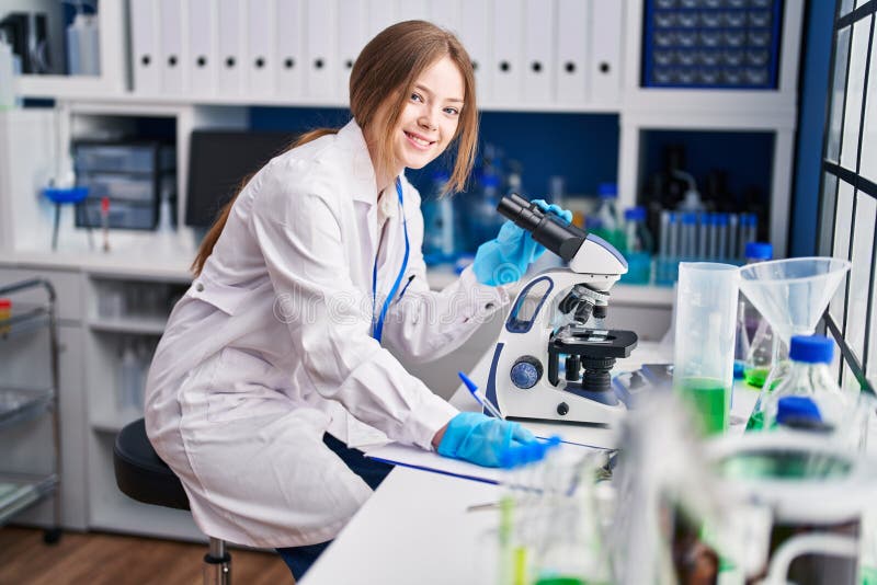 Young Caucasian Woman Scientist Using Microscope Write on Document at ...
