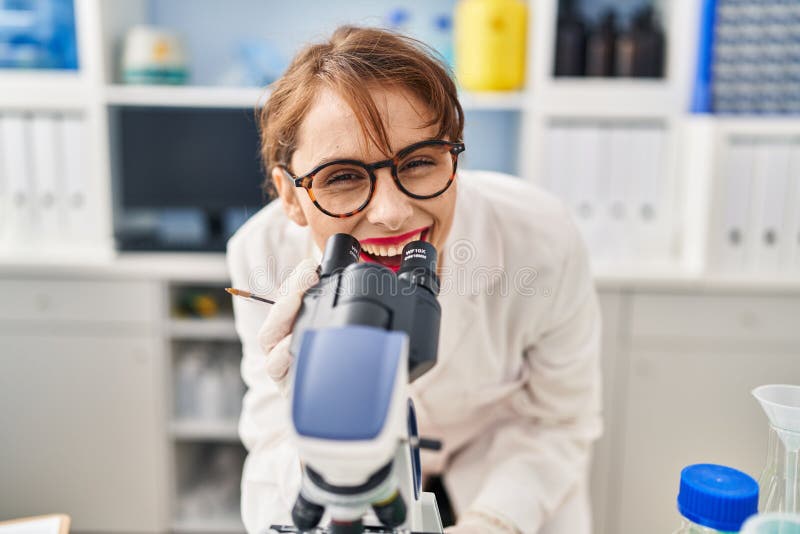 Young Caucasian Woman Wearing Scientist Uniform Using Microscope at ...
