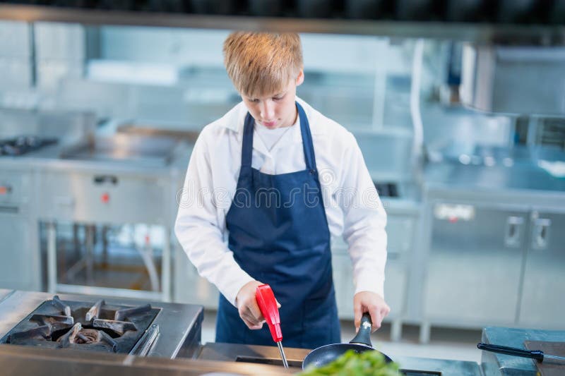 Young Chef Cooking at Restaurant Kitchen Stock Image - Image of uniform ...