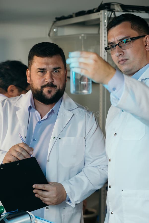 Man Checking Liquid through Magnifying Glass Stock Photo - Image of ...