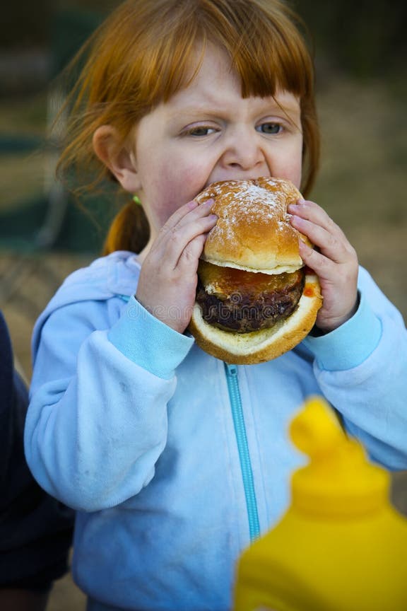 Young Child Eating Hamburger Stock Photo - Image of pensive, lunch ...