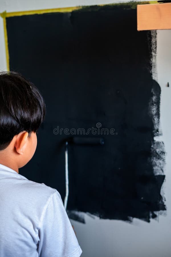 Young Child Painting a Wall in Black Colour. View from Behind Stock ...