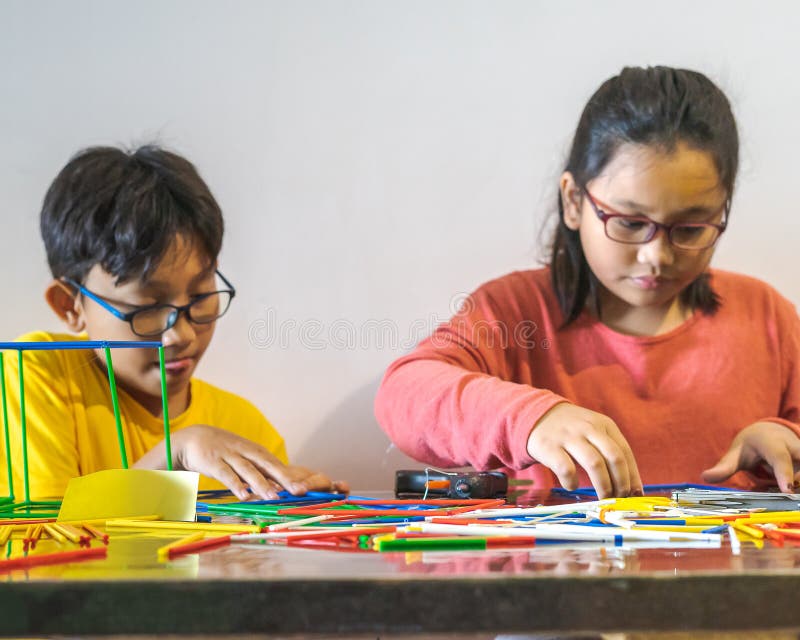 Young Children are Constructing Colorful Plastic Sticks with Glue Gun ...