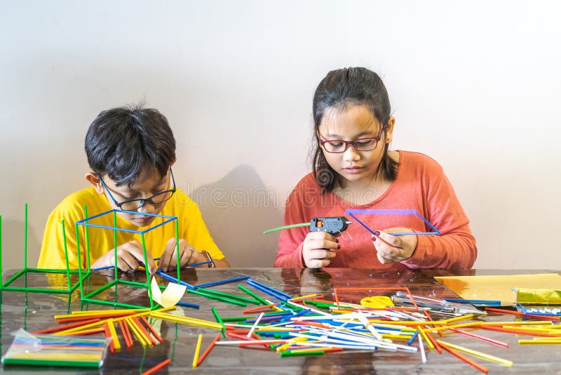 Young Children are Constructing Colorful Plastic Sticks with Glue Gun ...