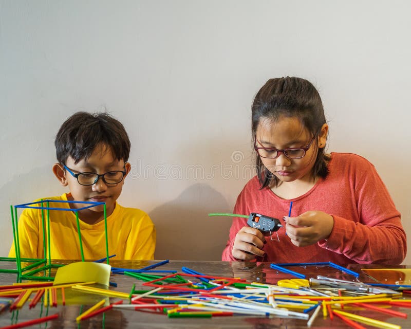 Young Children are Constructing Colorful Plastic Sticks with Glue Gun ...